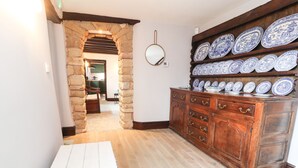 Um corredor com um arco de pedra que dá para uma área de cozinha.