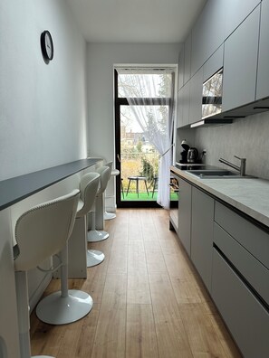 Apartamento Deluxe, vários quartos, varanda, Vista para a cidade | Cozinha privada | Um frigorífico, um micro-ondas, um forno, uma placa de cozinha 