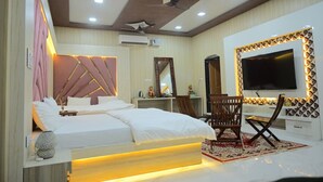 Quarto moderno com cama, televisão e ventoinha no teto.
