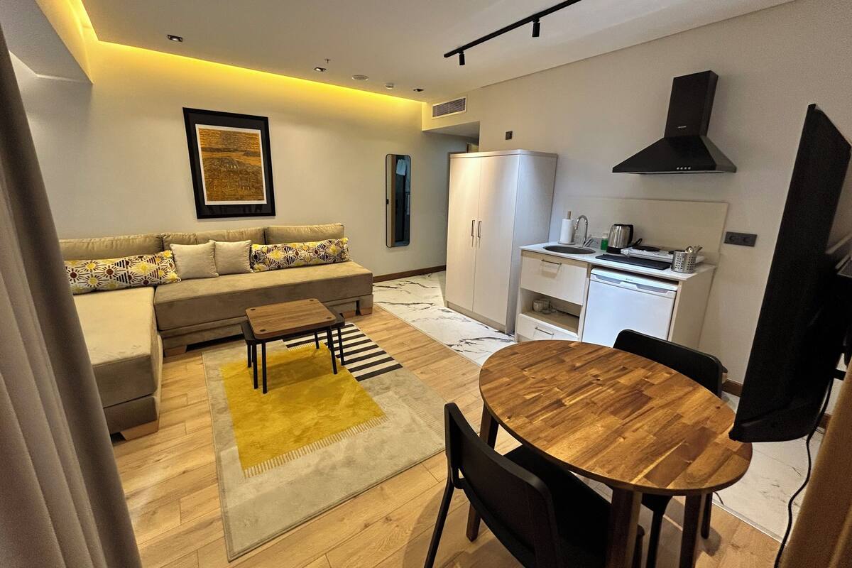 Um apartamento moderno com sala de estar, cozinha compacta e espaço para refeições.