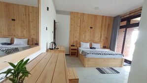 Quarto moderno com paredes de painel de madeira, duas camas com roupa de cama estampada em padrão de zebra, um banco de madeira, uma planta em vaso e uma pequena mesa.