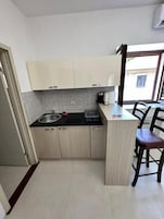Estúdio econômico, 1 cama Queen, banheiro privativo | Cozinha privada | Refrigerador em uma área comum