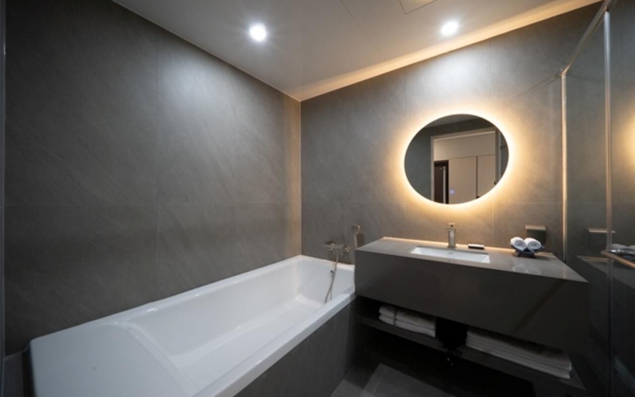 Quarto com design assinado, vista para a cidade | Banheiro | Chuveiro, secador de cabelo, toalhas de banho, sabonete