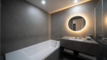 Quarto com design assinado, vista para a cidade | Banheiro | Chuveiro, secador de cabelo, toalhas de banho, sabonete