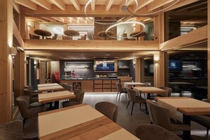 Um interior moderno com vigas de madeira, espaço para cozinha e área de refeições.