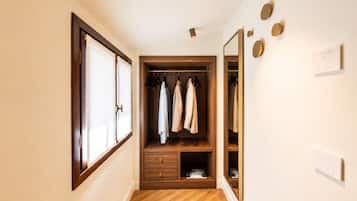 Um corredor com um guarda-roupa de madeira, um espelho e uma porta com janela.