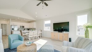Uma sala de estar moderna com sofá, pufê e televisão.