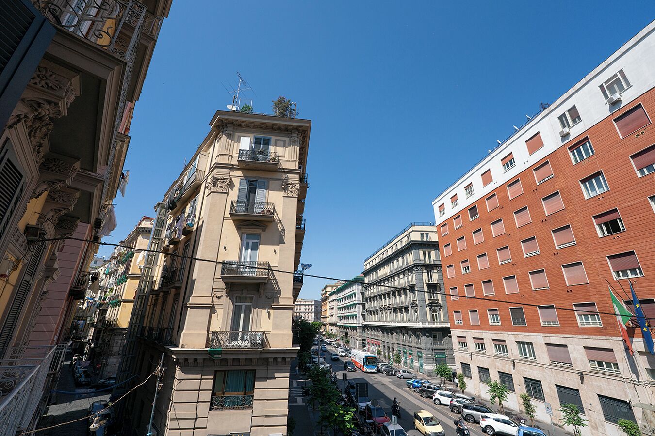 Um edifício com várias andares, varandas e vista para a rua.