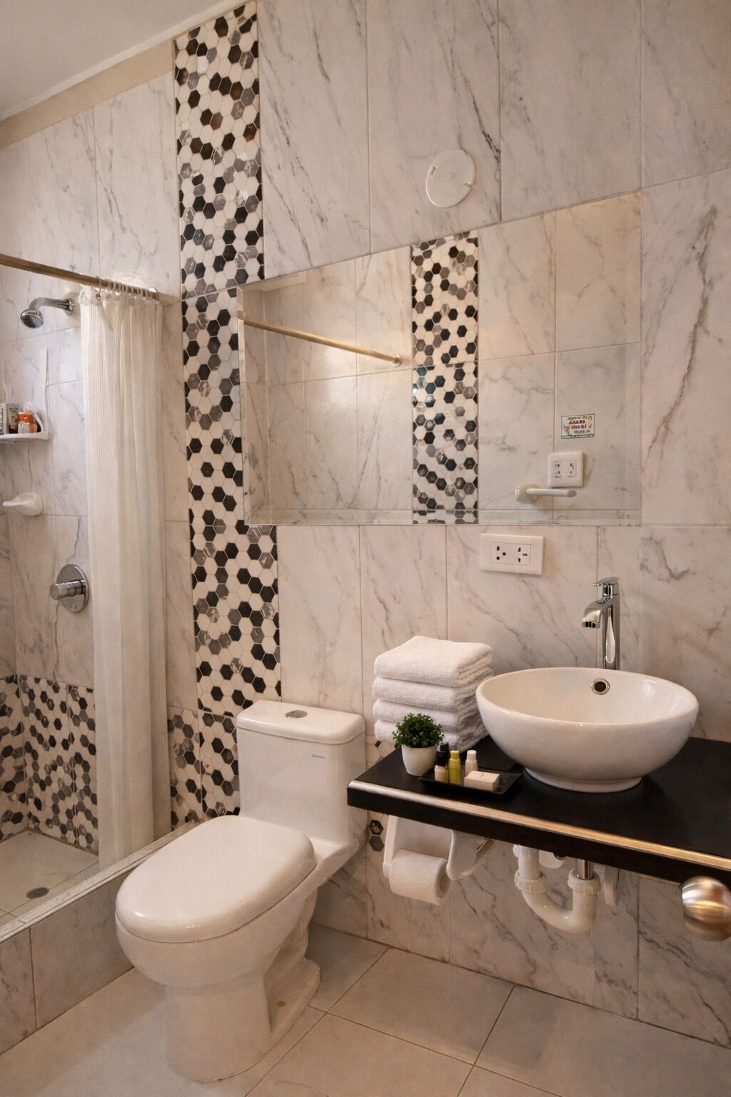 Chuveiro, toalhas de banho, sabonete, papel higiênico