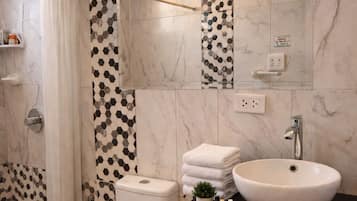 Chuveiro, toalhas de banho, sabonete, papel higiênico