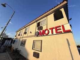 Um edifício com uma placa que diz 'Motel' e um letreiro em forma de sino indicando 'Bell Motel'.