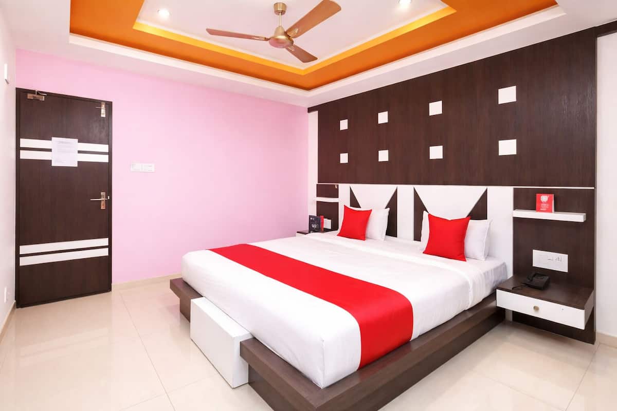 Quarto com uma cama, mesa de cabeceira, ventilador de teto e porta.