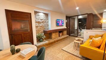 Apartamento Deluxe, vista parcial para o mar | Sala de estar | Televisor de 40 polegadas com canais digitais