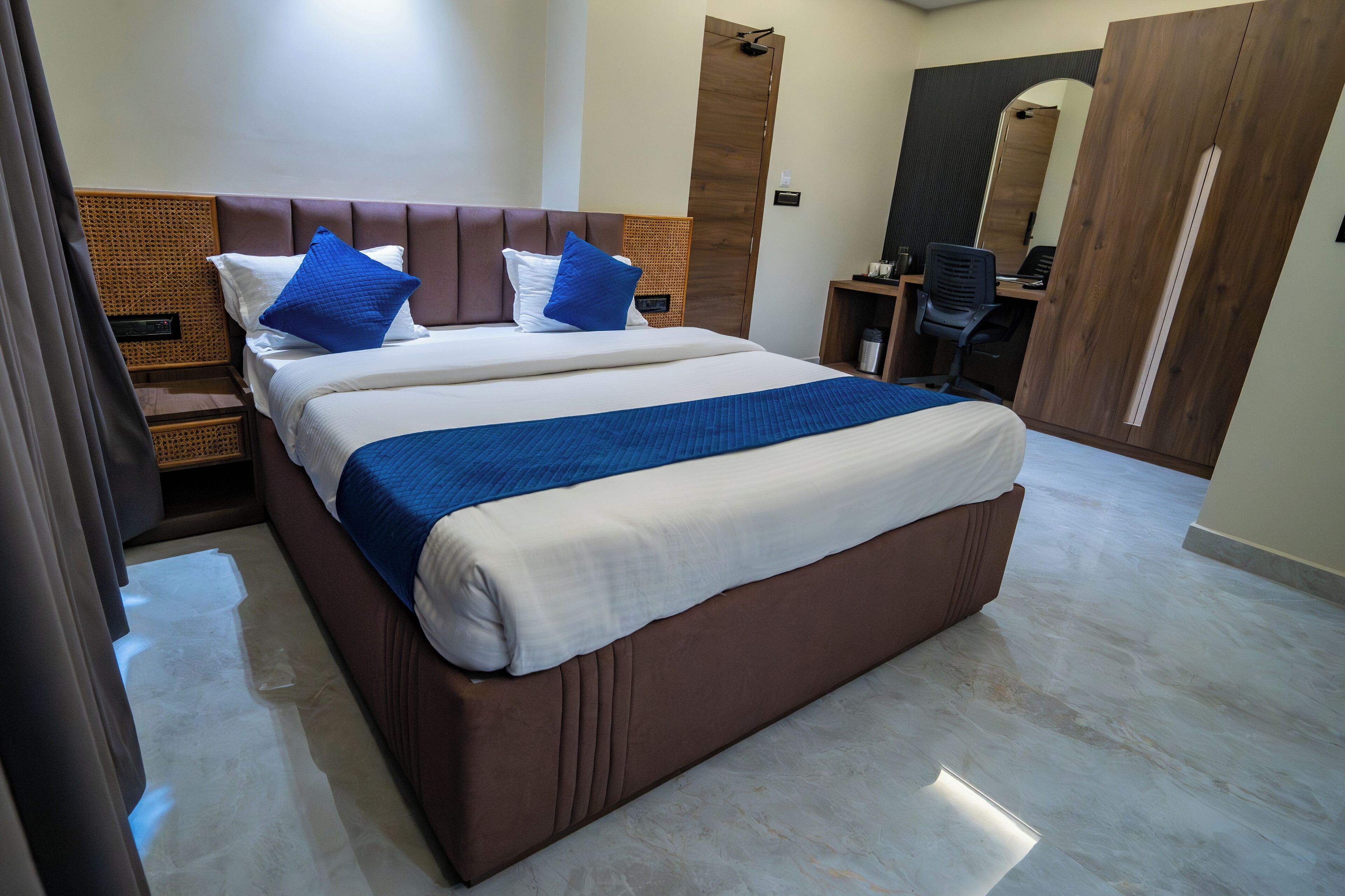 Quarto de hotel com uma cama grande, uma escrivaninha e um guarda-roupa.