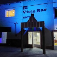 Exterior do Hotel El Viejo Bar, com uma placa grande e uma entrada pequena.