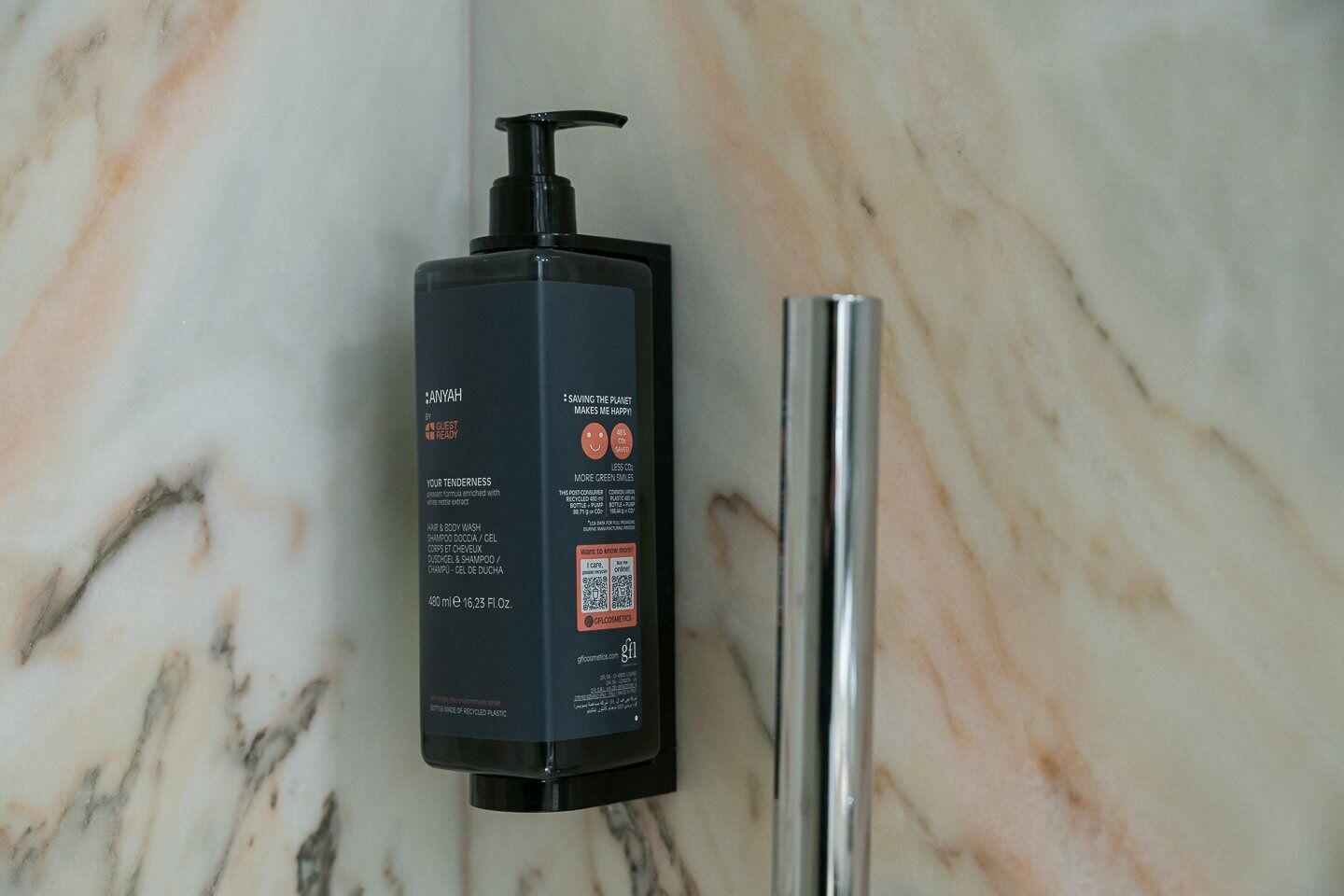 Uma garrafa preta de lavagem para cabelo e corpo Aniyah sobre uma superfície de mármore.