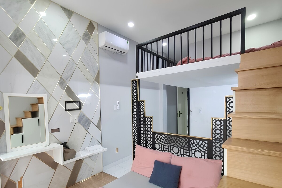 Quarto com cama de solteiro, mesa de cabeceira, espelho e parede estampada.