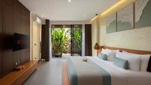 Quarto de hotel moderno com uma cama grande, TV de tela plana e vista para o verde através das portas de vidro.