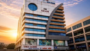 Um edifício de hotel moderno com fachada curva, vários andares e diversos anúncios.