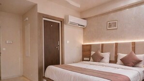 Quarto com estrutura de cama de madeira, colchão branco e cabeceira com iluminação embutida.