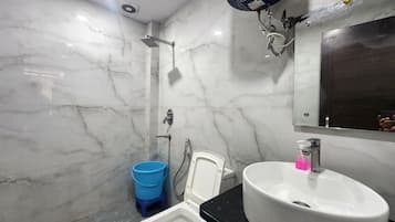 Chuveiro, toalhas de banho, shampoo, papel higiênico