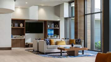 Uma sala de estar moderna com sofá, mesa de centro e painel de entretenimento.