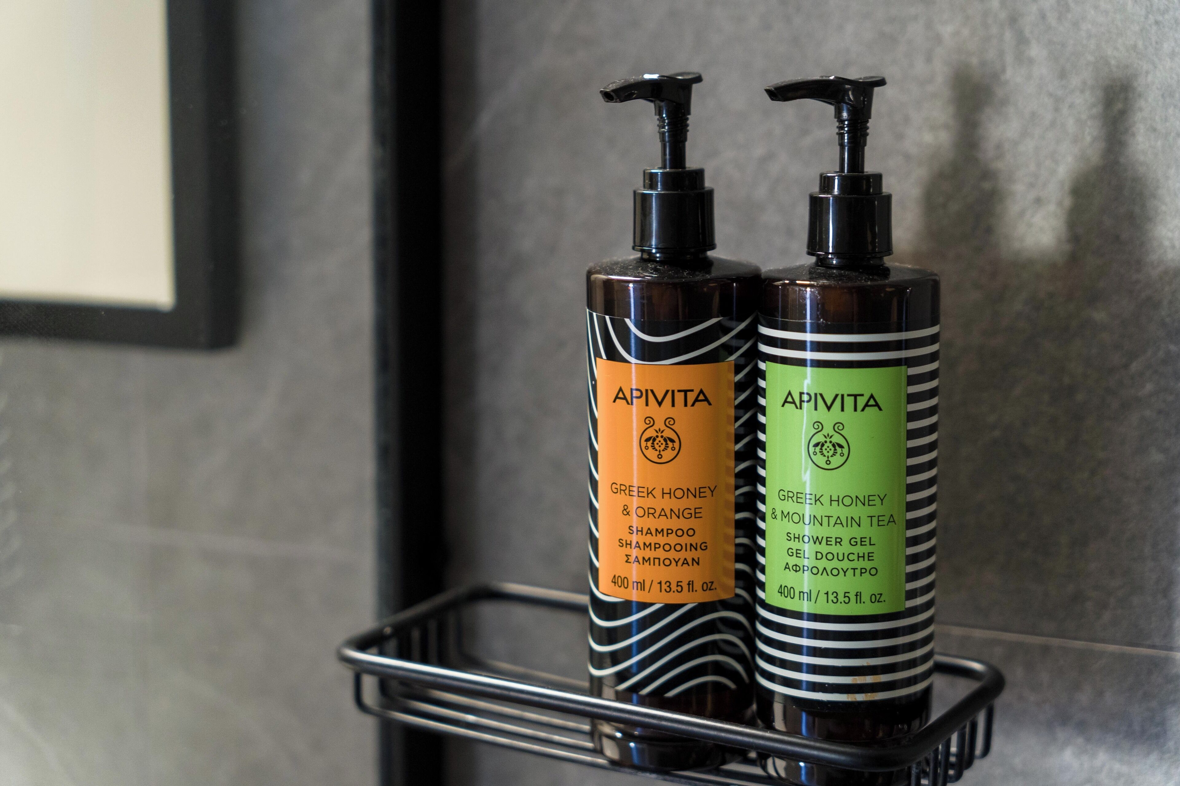 Duas embalagens de shampoo e gel de banho APVITA numa prateleira de metal.