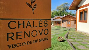 Placa para Chalés Renovó com vista para um edifício com telhado de cerâmica e um jardim.