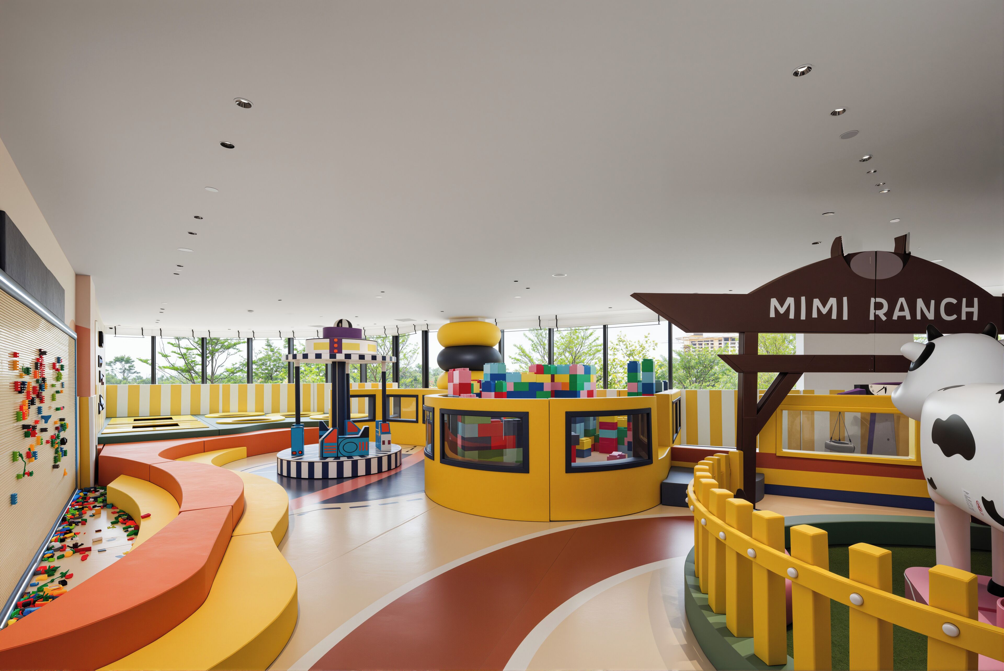 Uma área de recreação infantil com estruturas coloridas e uma placa que diz 'Mimi Ranch'.