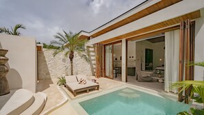 Uma área de piscina moderna ao ar livre, com uma espreguiçadeira e um muro de pedra.
