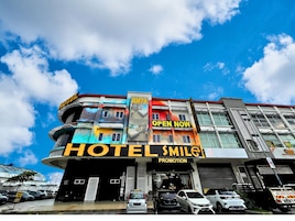 Hotel com fachada moderna, várias varandas e um letreiro chamativo que diz 'ABERTO AGORA'.