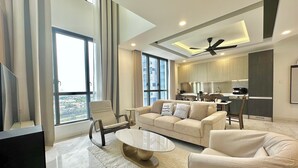 Uma sala de estar moderna com sofá, mesa de centro e uma área de jantar com cadeiras e mesa.
