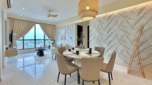 Uma área de refeições moderna com uma mesa redonda, cadeiras e um lustre.