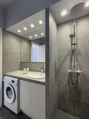 Apartamento, vista para o jardim | Casa de banho | Um polibã, sabão, champô, papel higiénico 