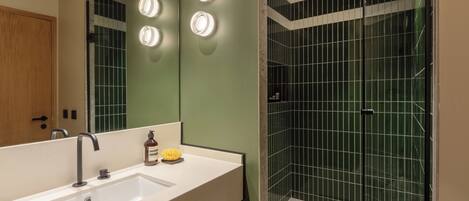 Uma casa de banho moderna com um espelho grande, lavatório e zona de duche.