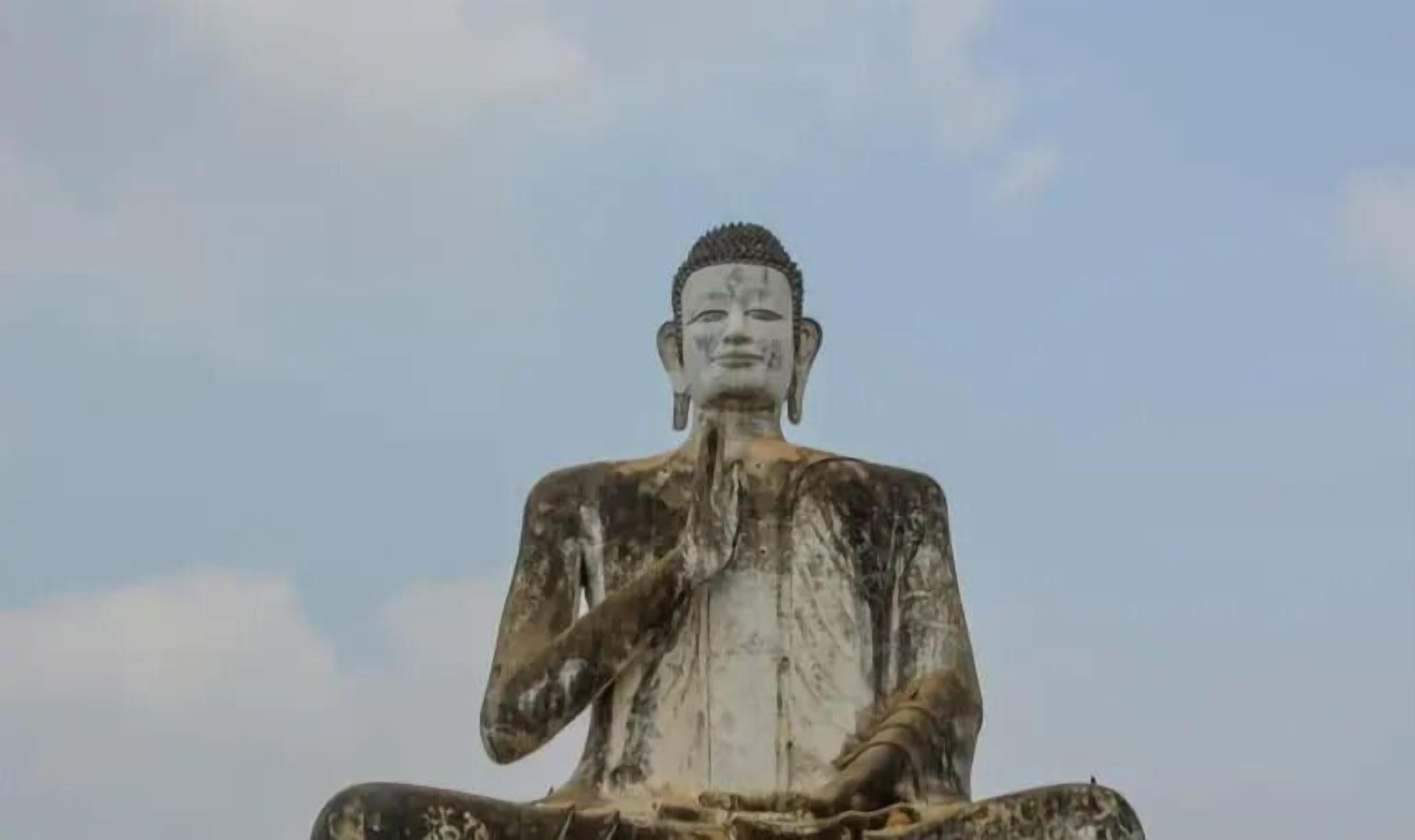 Uma grande estátua sentada em pose meditativa.