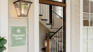 Uma escadaria leva a um quarto com uma placa indicando 'Dogwood Suite'.