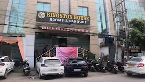 Um edifício com uma placa indicando 'Kingston House Rooms & Banquet'.