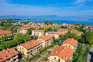 Zona residencial com edifícios altos, uma estrada central e um lago ao fundo.