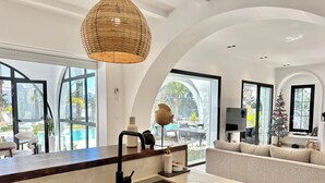 Cozinha moderna com uma ilha grande, pia embutida e área de jantar com vista para a piscina.