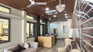 Decoração moderna com balcão de recepção, área de estar e um lustre.