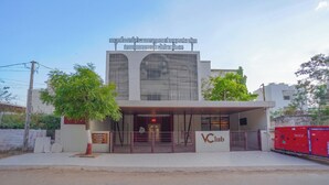 Um edifício moderno com telhado plano, grandes janelas e uma placa com a inscrição 'V Club'.