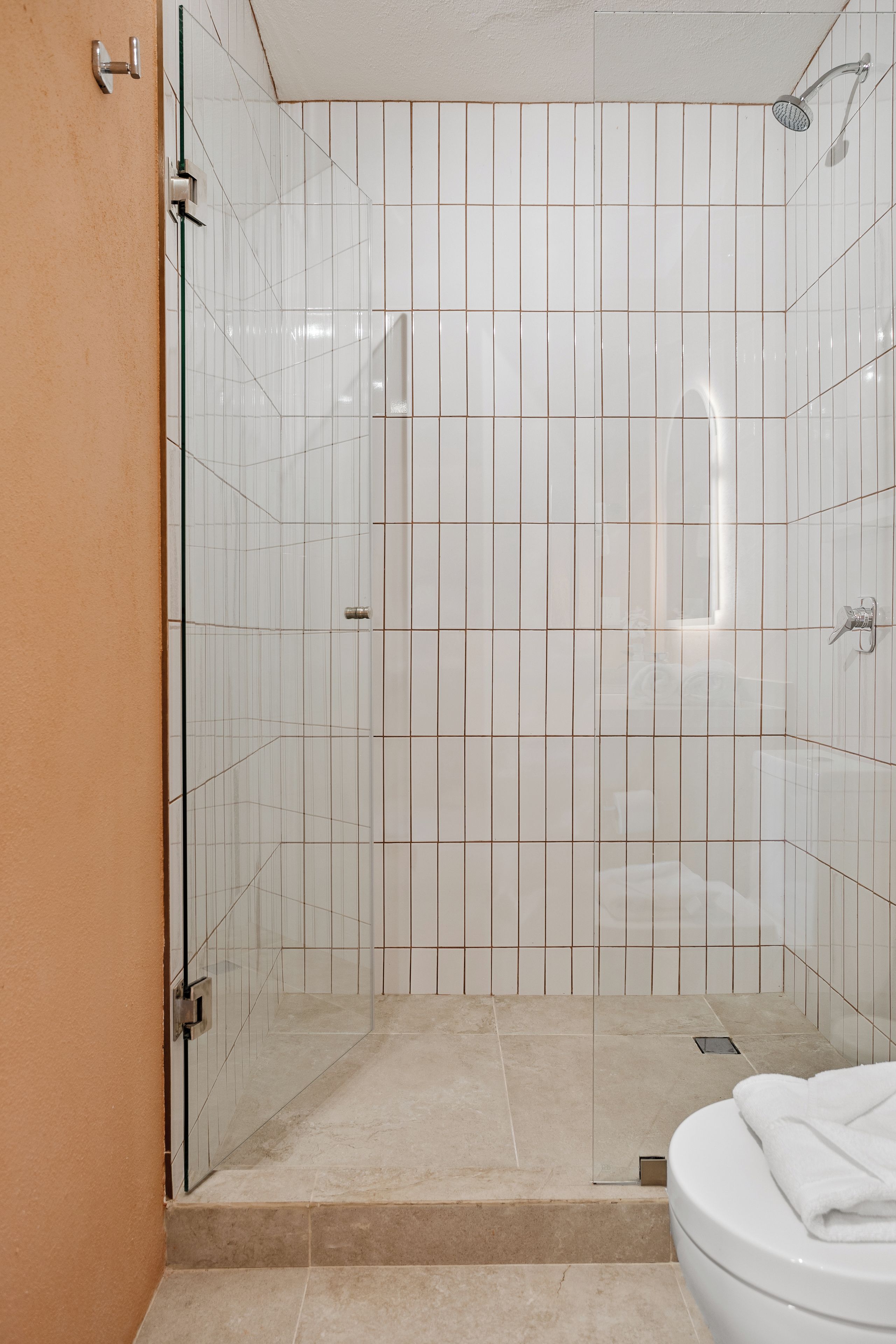 Um banheiro moderno com box de vidro, vaso sanitário e pia.