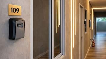 Um corredor com uma placa de número '109', uma porta e um extintor de incêndio.