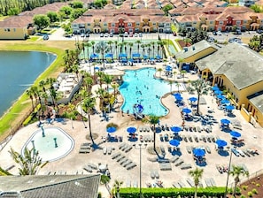 Resort com uma grande piscina, espreguiçadeiras e quadra de tênis.