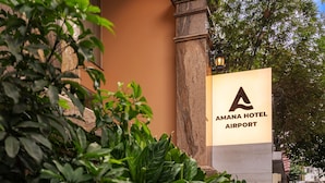 Exterior do Hotel Amanah Airport, com uma placa de destaque.