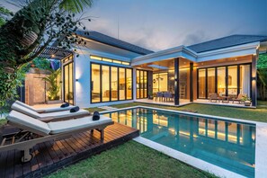 Uma casa moderna com piscina, área de estar ao ar livre e interior bem iluminado.