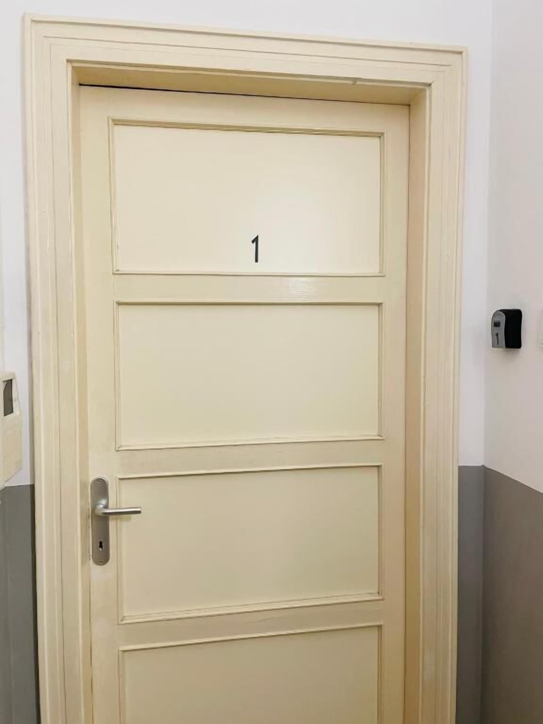 Uma porta com o número 1, uma fechadura e uma maçaneta.