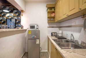 Apartamento básico, 2 quartos, cozinha, no piso térreo | Cozinha privada | Geladeira, micro-ondas, fogão, cooktop
