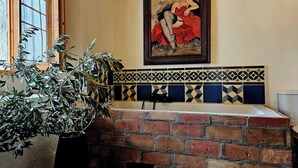Um banheiro com área de chuveiro em azulejo, parede de tijolos e um quadro pendurado na parede.